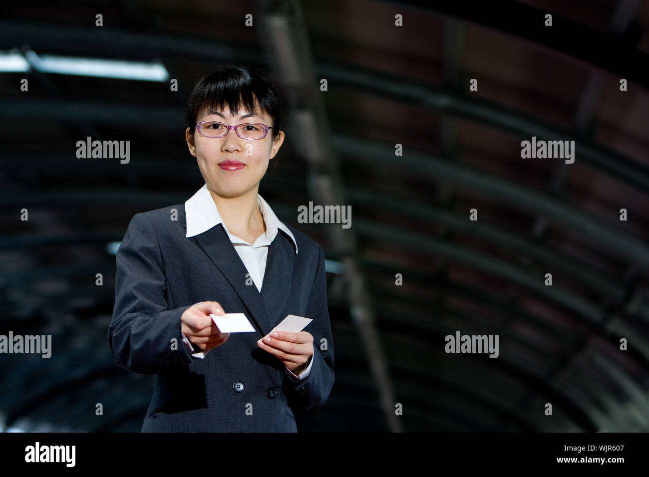 Asian woman giving her business calling card with a friendly smile ...