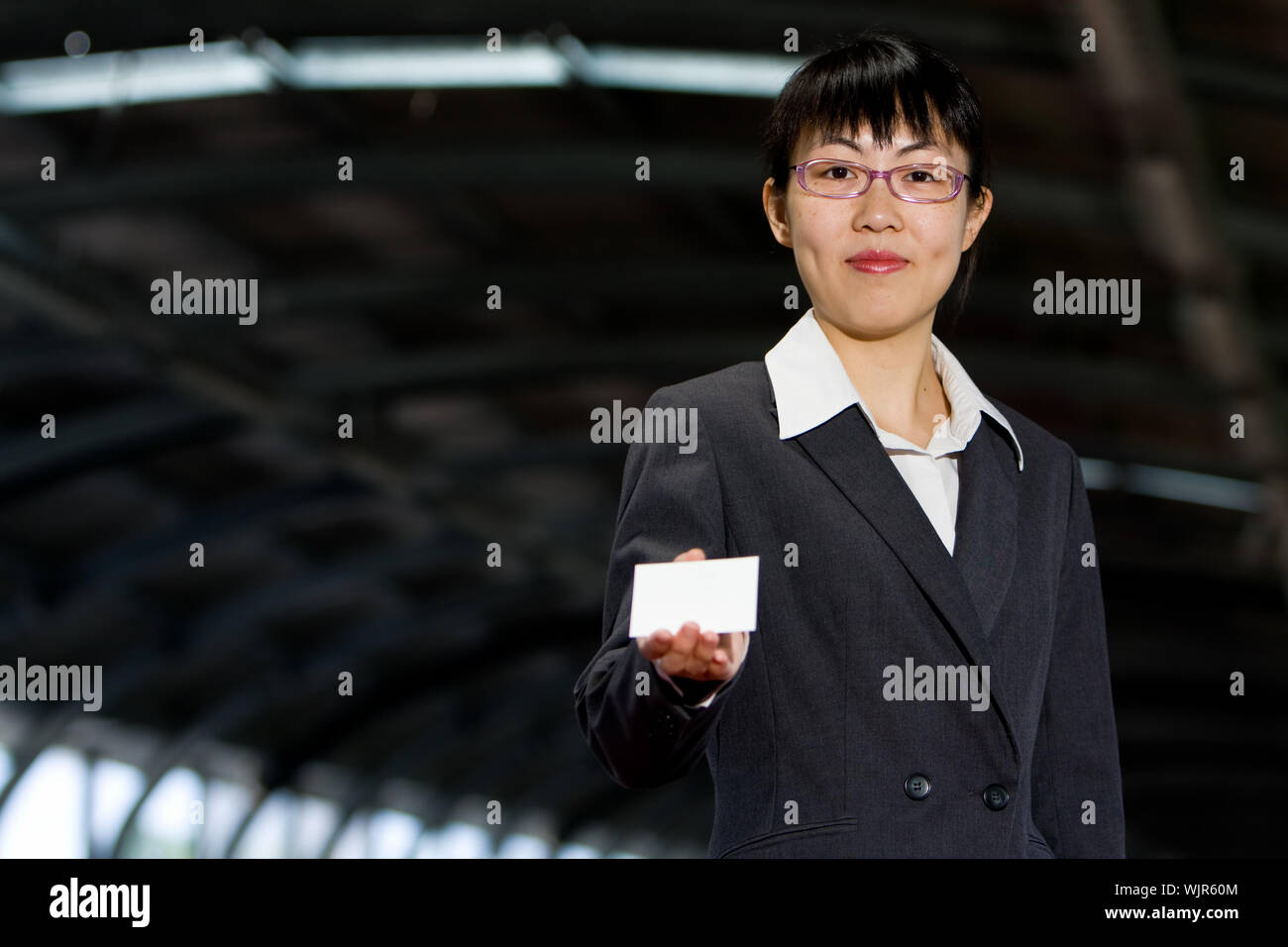 Asian woman giving her business calling card with a friendly smile ...