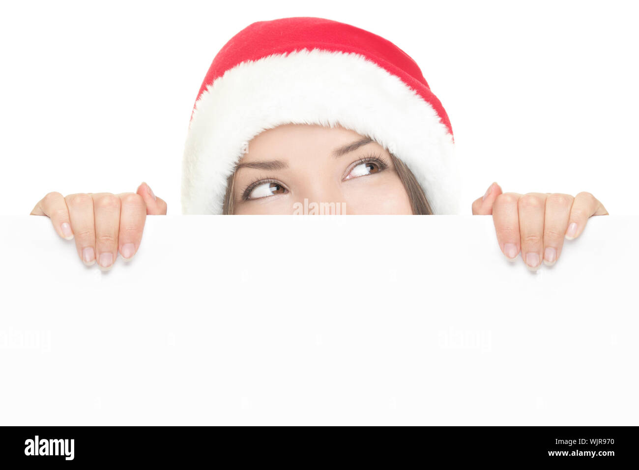 Santa girl peeking over sign board Stock Photo - Alamy