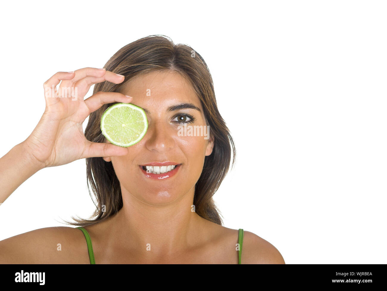 Beautiful young woman eating a lime slice Stock Photo - Alamy