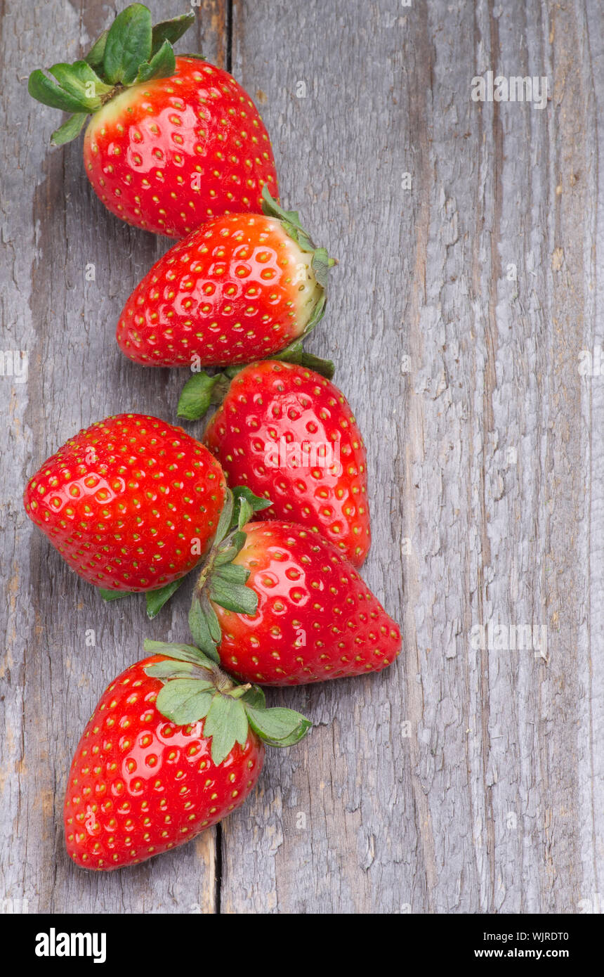 Ripe Strawberries Full Body In a Row isolated on Wooden background. Top ...
