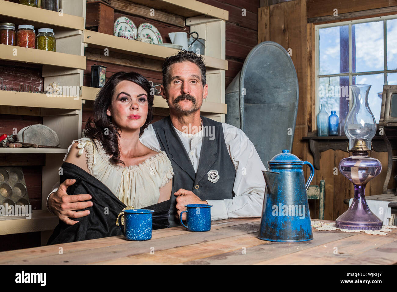 Western sheriff poses with a woman for a portrait inside a house Stock ...