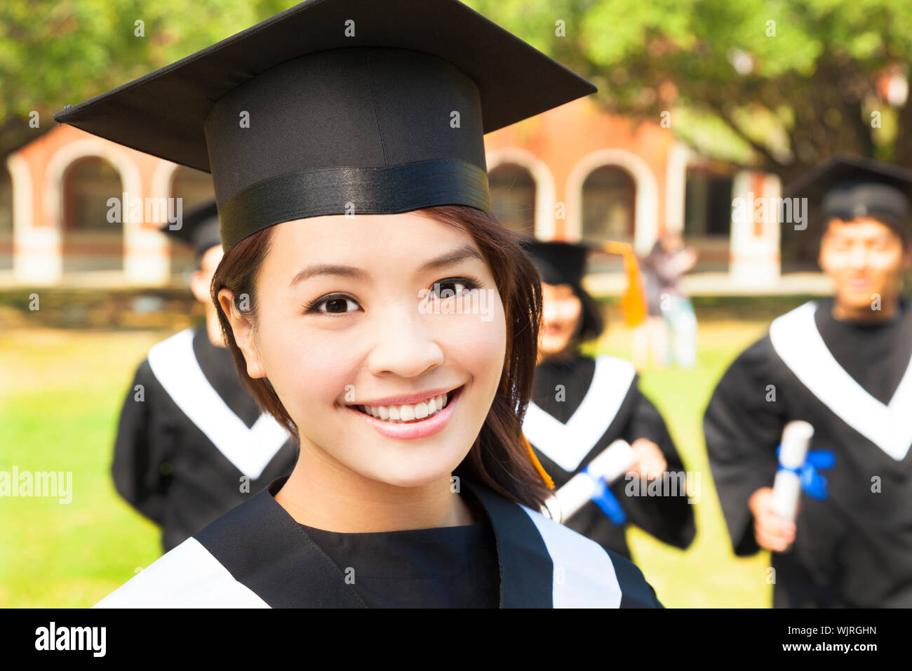 beautiful female college graduate with classmates at ceremony Stock ...