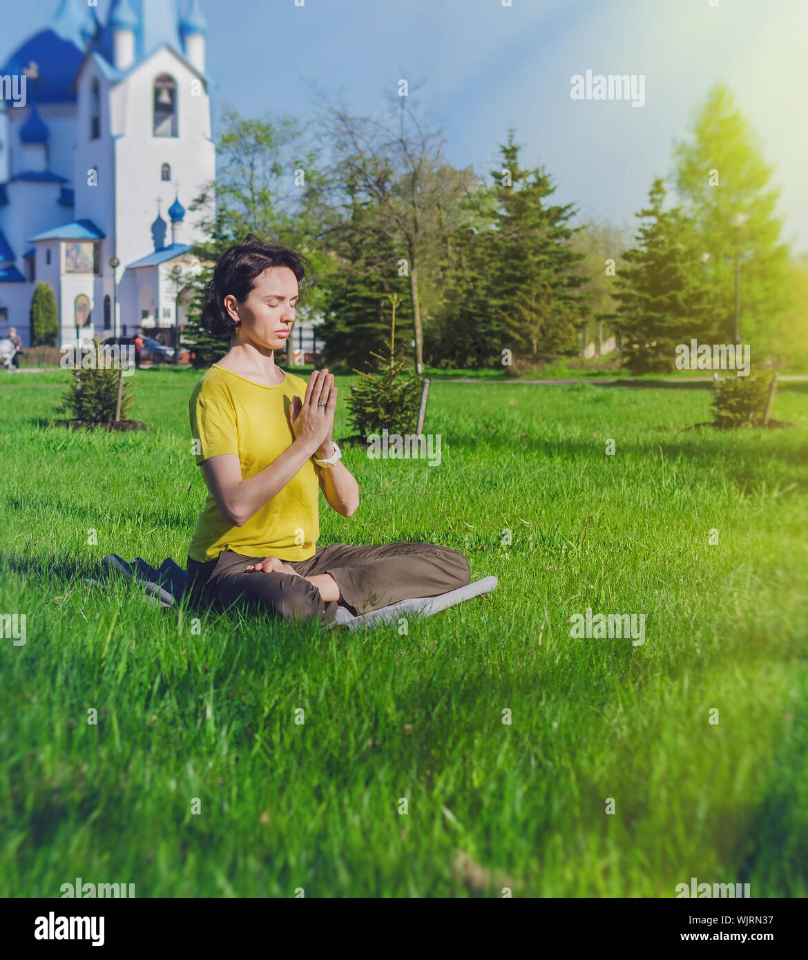 Young woman in prayer sitting hi-res stock photography and images - Alamy