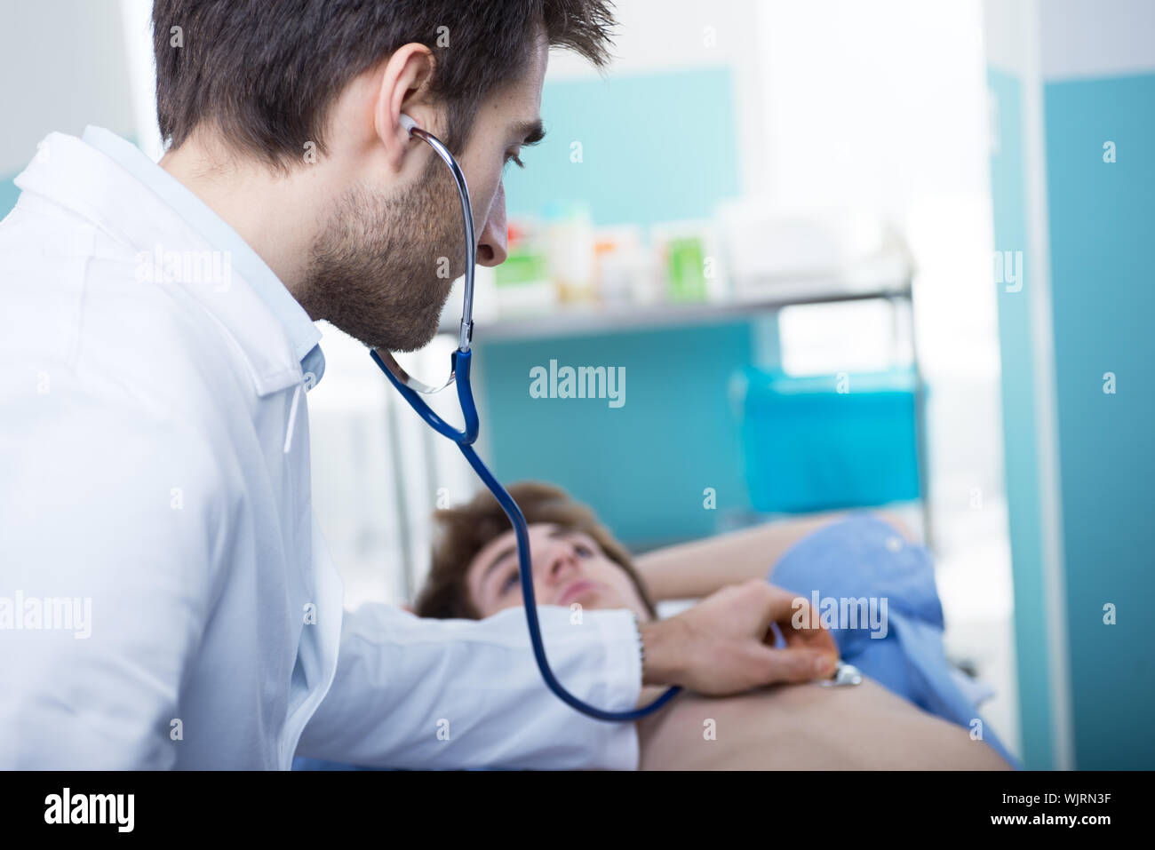 Doctor examining patient's heartbeat with a stethoscope Stock Photo - Alamy