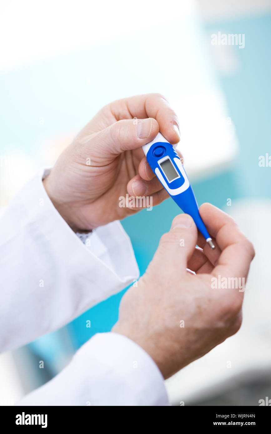 Doctor checking temperature with a thermometer, hands close-up Stock ...