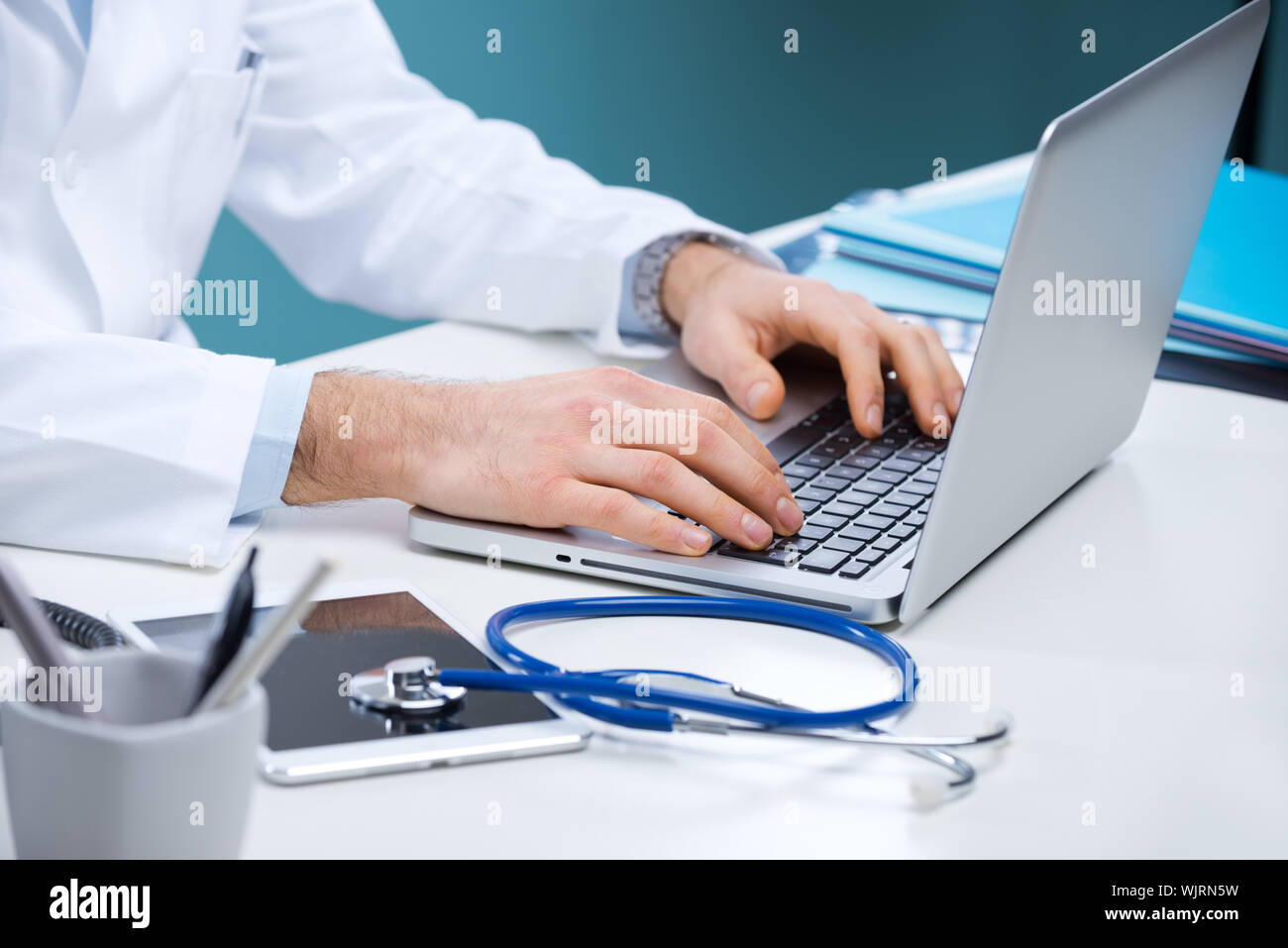 Doctor working at his desk with stethoscope, laptop and tablet Stock ...