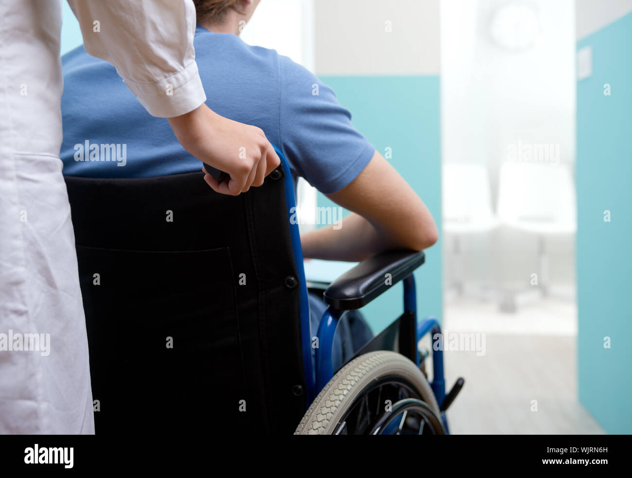 Female nurse pushing her patient on a wheelchair Stock Photo - Alamy