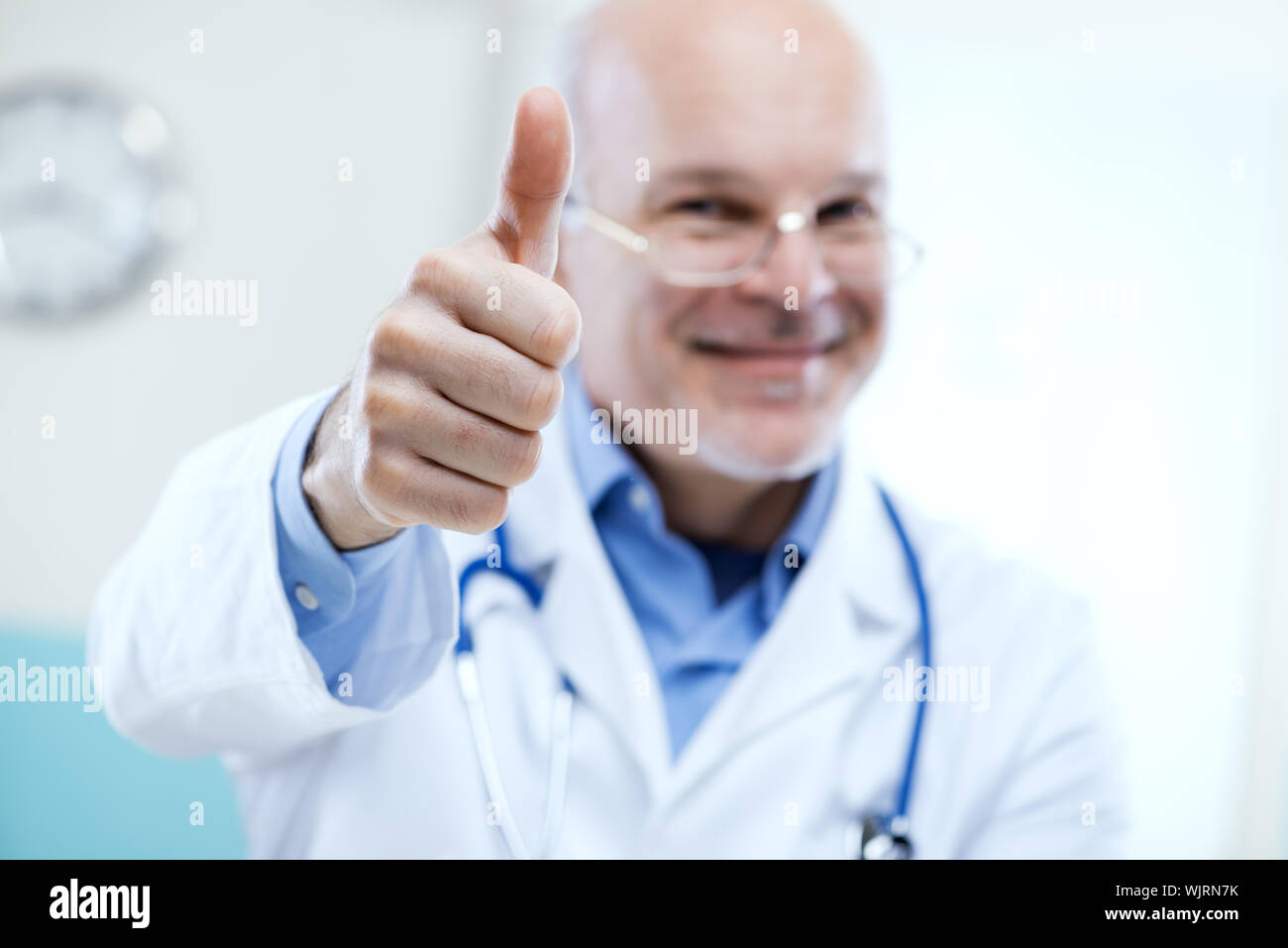 Friendly smiling doctor with thumbs up at the hospital Stock Photo - Alamy