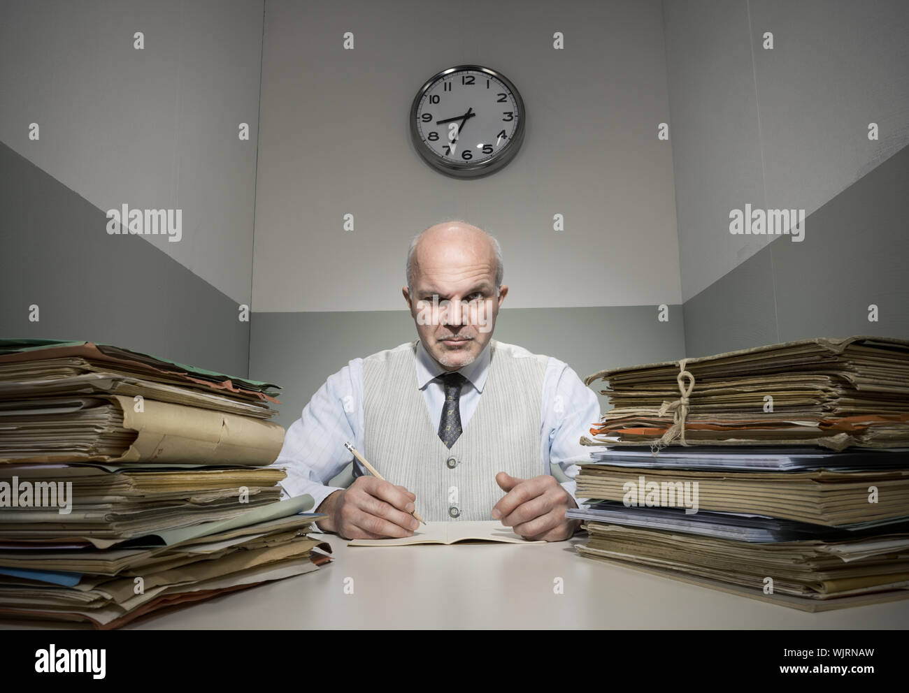 Angry office worker with piles of folders in a small room Stock Photo ...