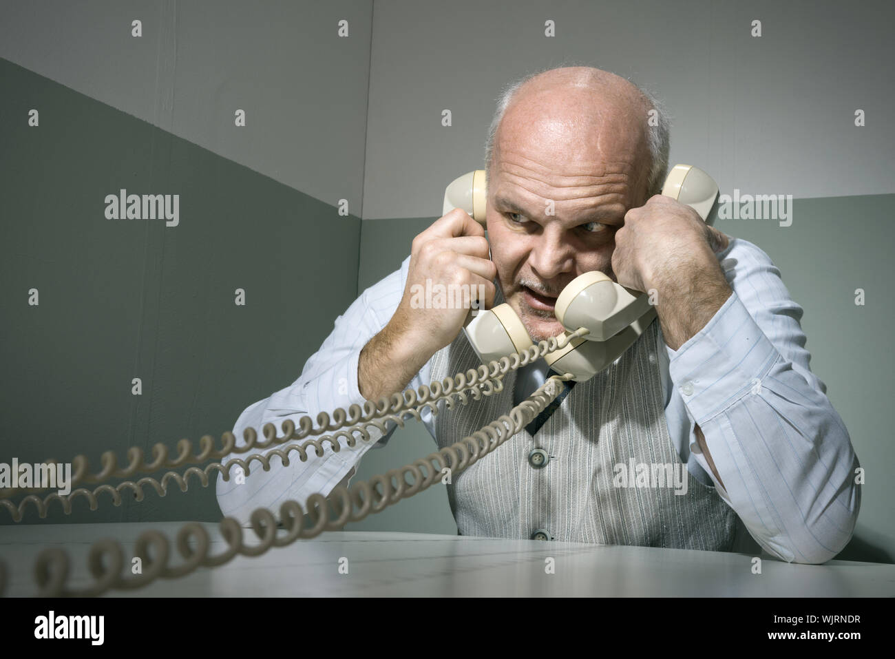 Stressed overworked businessman talking on the phone, vintage style ...