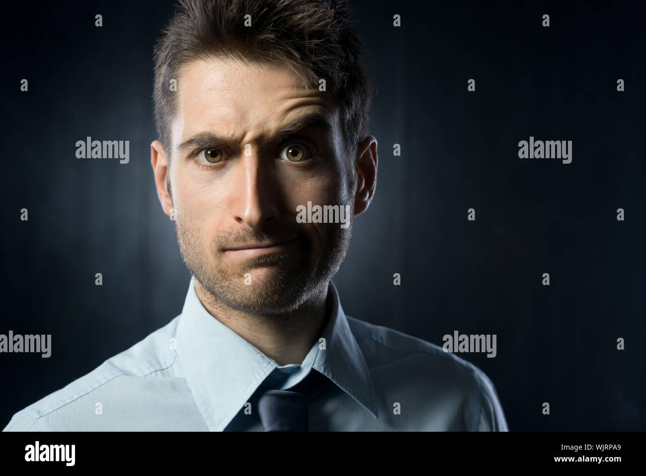 Young businessman with raised eyebrow and doubtful expression Stock ...