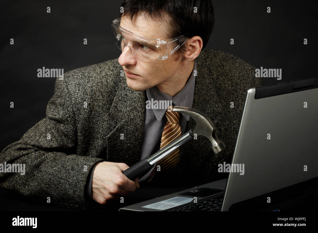 The person is going to break the computer by means of a hammer Stock ...