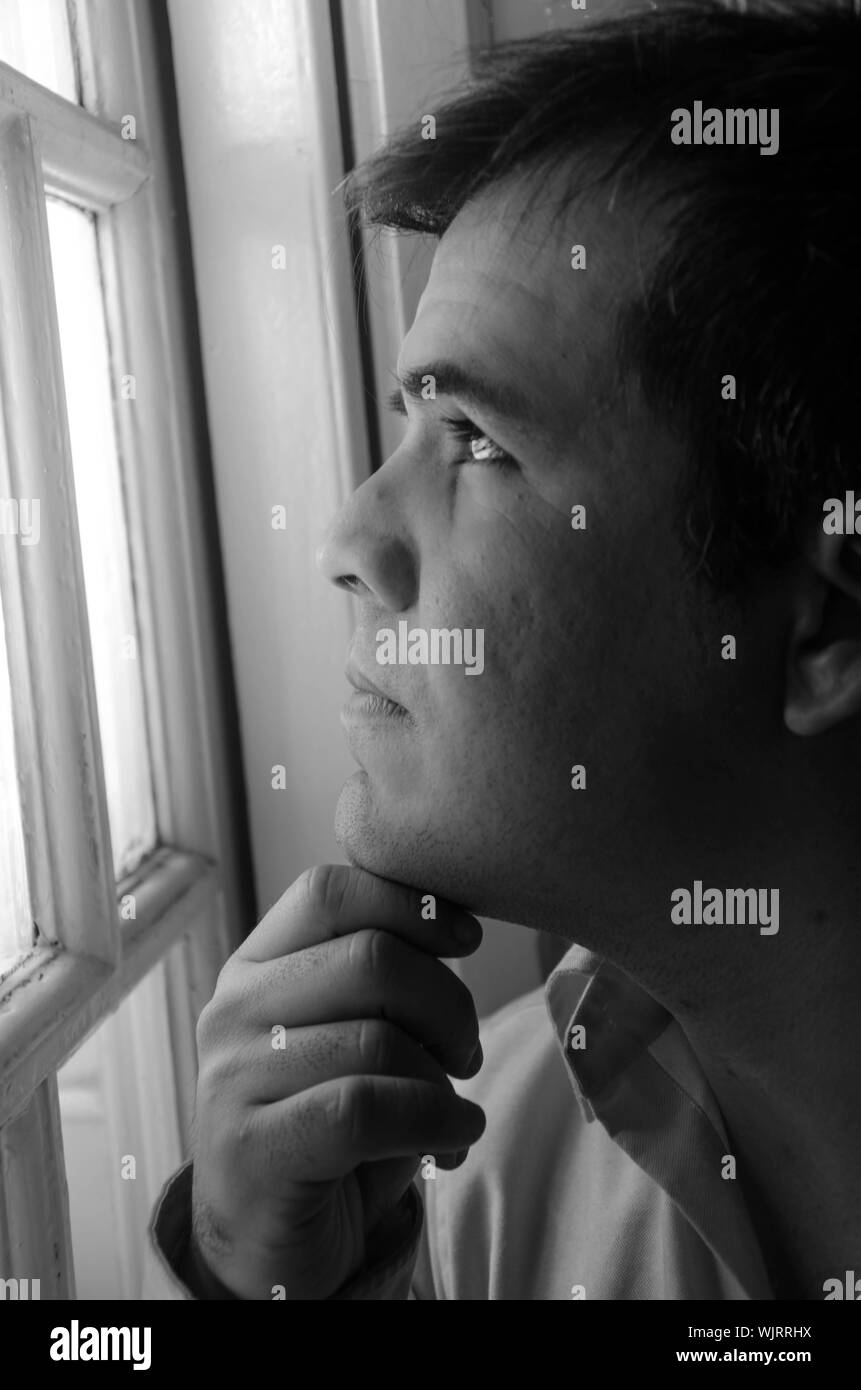 Man looking through window Black and White Stock Photos & Images - Alamy