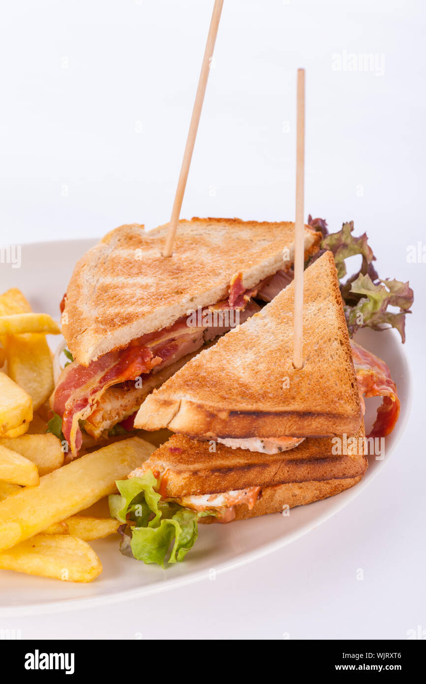 Club sandwich on toasted white bread with a meat filling served with ...