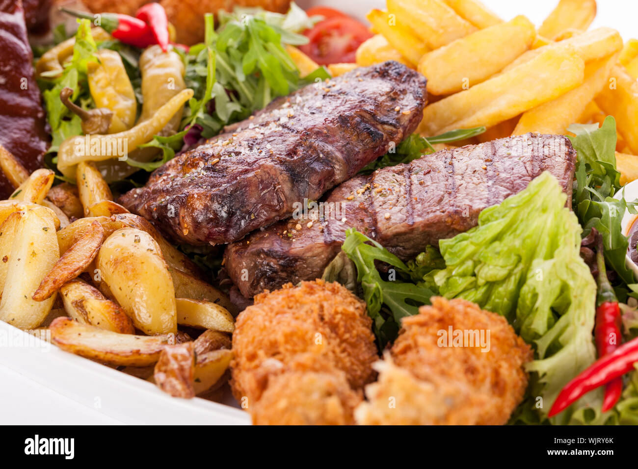 Wholesome platter of mixed meats including grilled steak, crispy ...