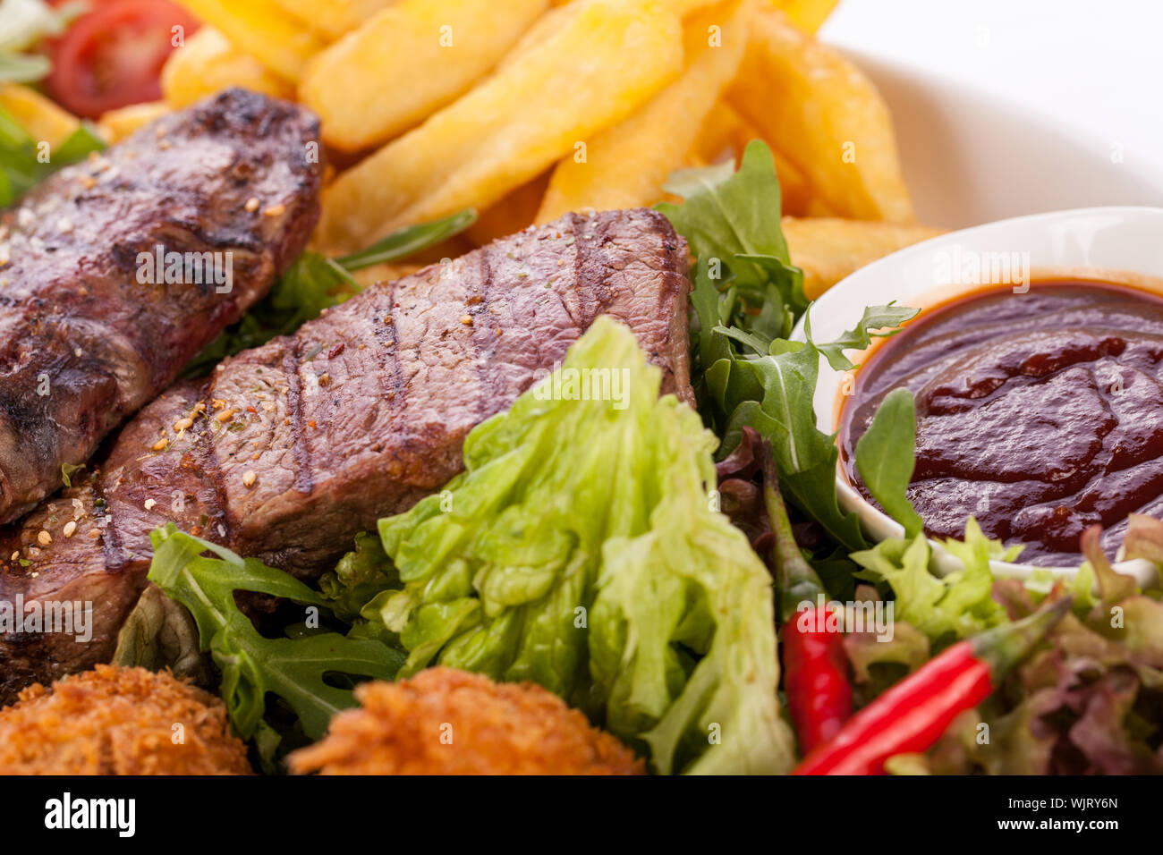 Wholesome platter of mixed meats including grilled steak, crispy ...