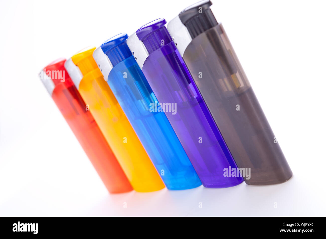 Row of vividly coloured plastic disposable lighters for smokers in red ...