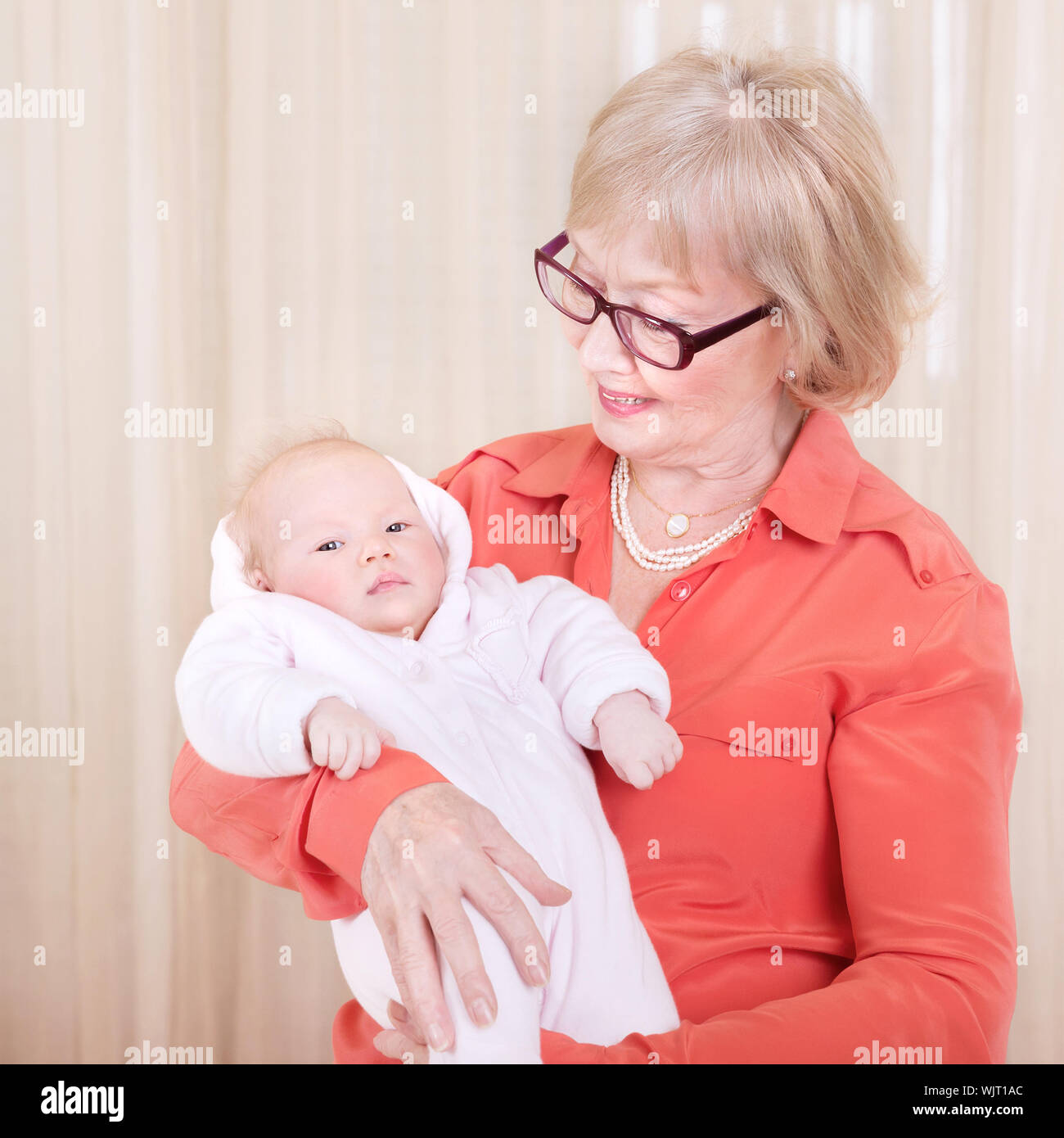 Happy granny holding newborn kid at home, enjoying sweet little ...