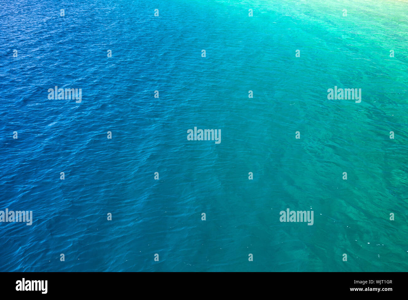 Blue water with sun reflections Stock Photo - Alamy