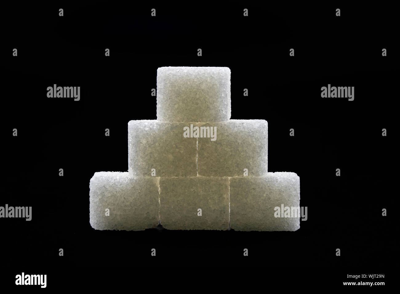 Sugar cubes lined up in pyramid shape. Black background Stock Photo - Alamy