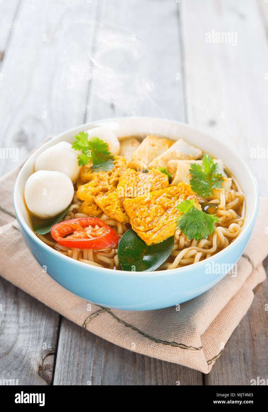 Spicy curry instant noodles. Asian cuisine, ready to serve on wooden ...