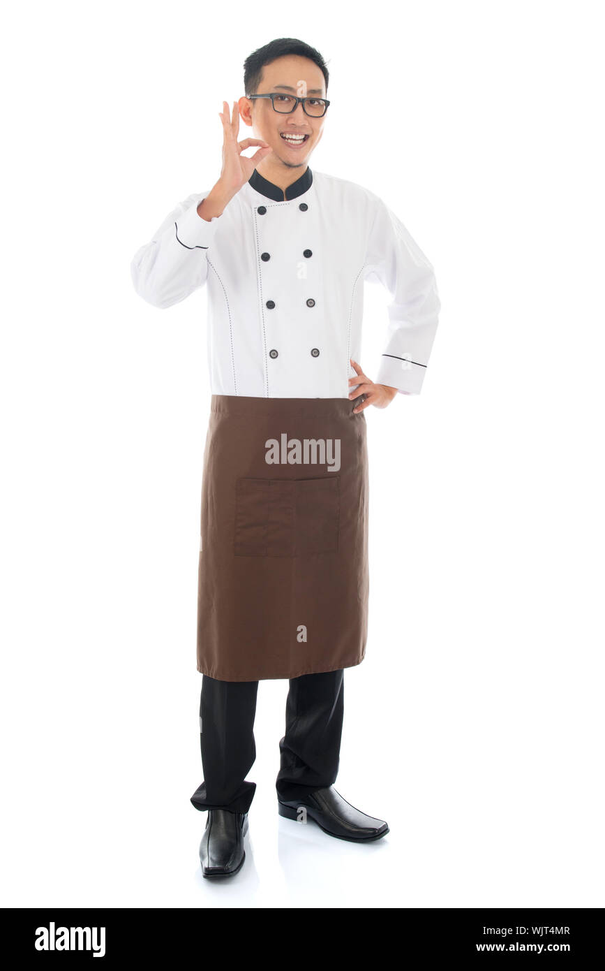 Full body portrait of Asian chef showing tasty and satisfied hand sign ...