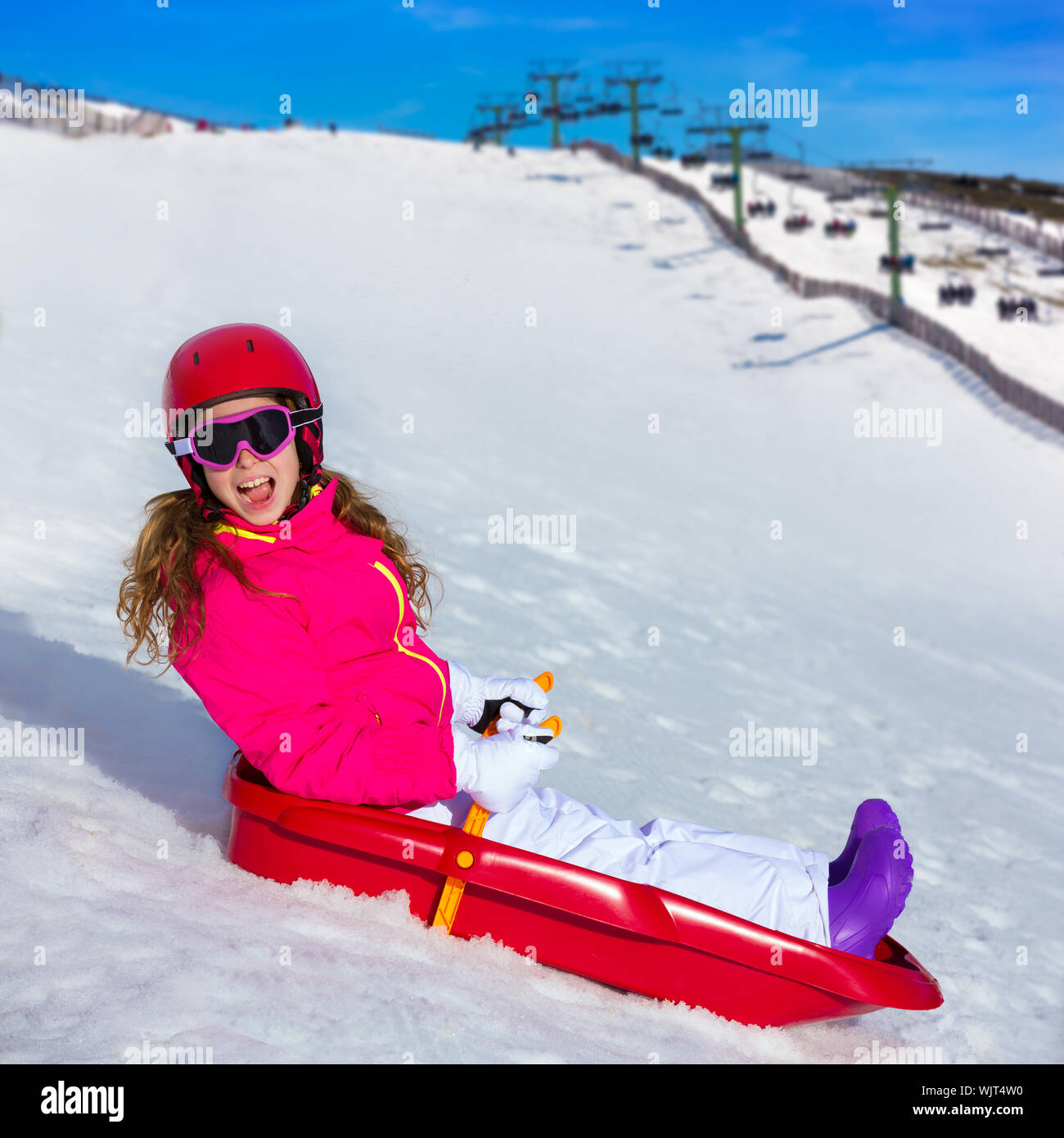Kid girl playing sled in winter snow with helmet ang goggles Stock ...