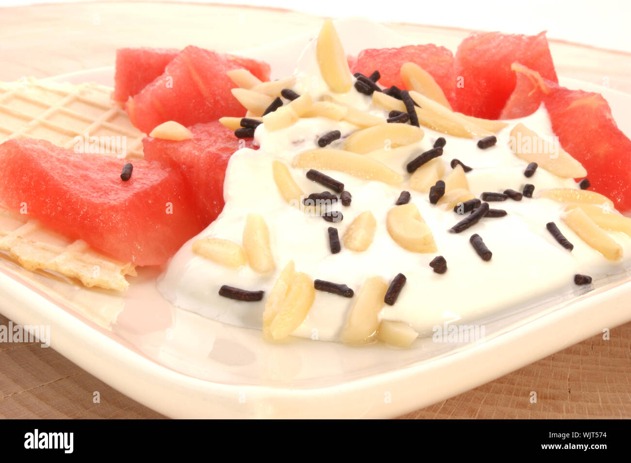Melon, wafer and cream on a white plate Stock Photo - Alamy
