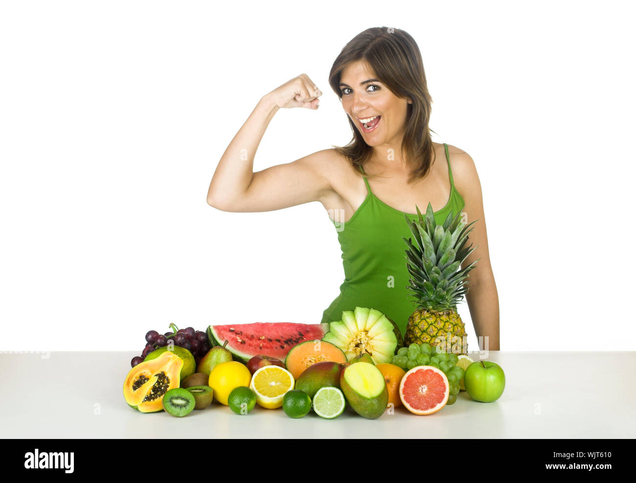 Beautiful and strong healthy woman with a lot of fruits in front of her ...