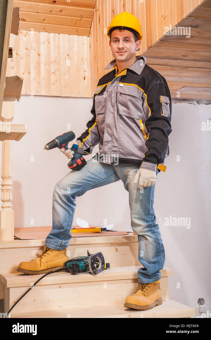 contractor standing on ladder and holding cordless drill Stock Photo ...