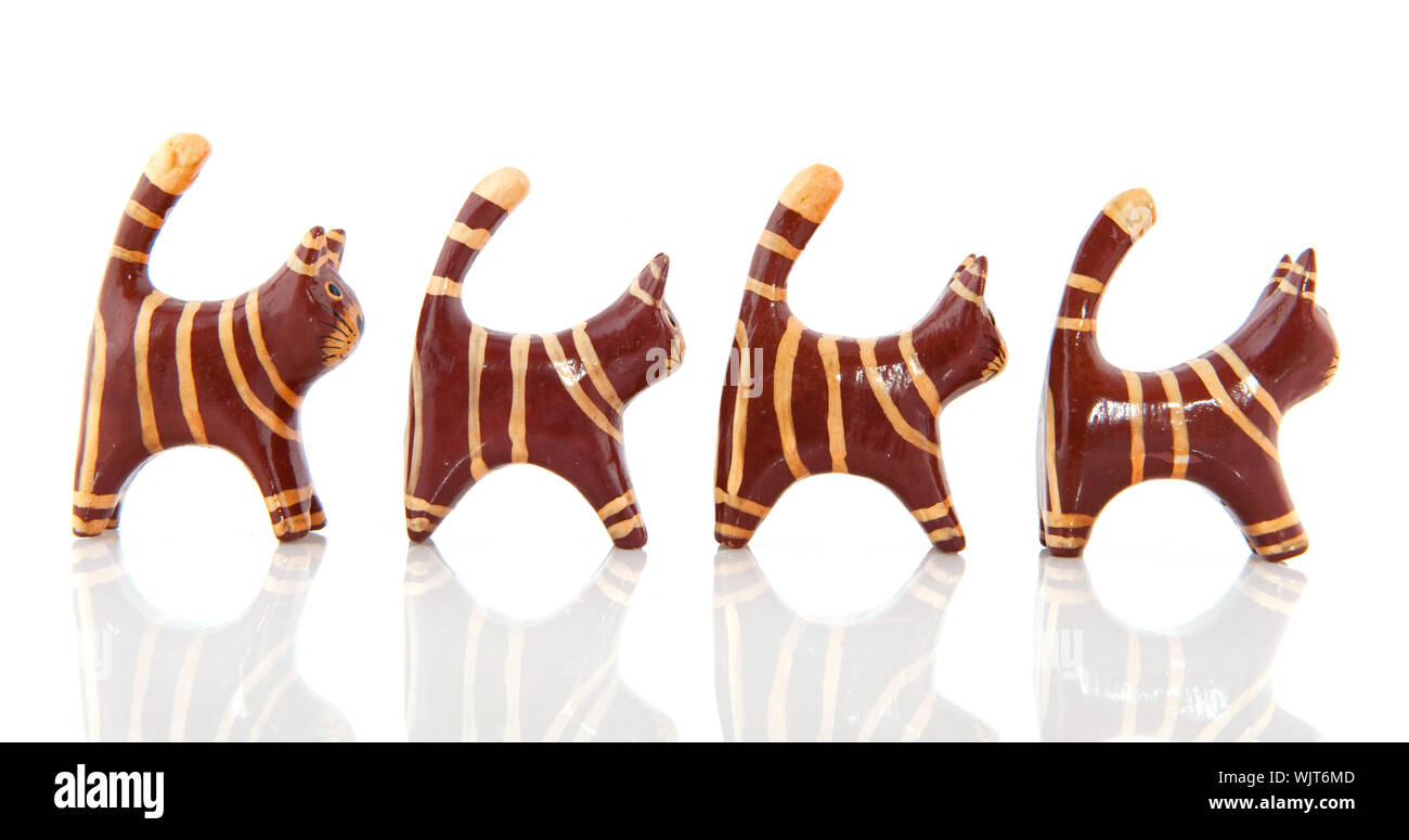 Little wooden striped cats isolated over white Stock Photo - Alamy