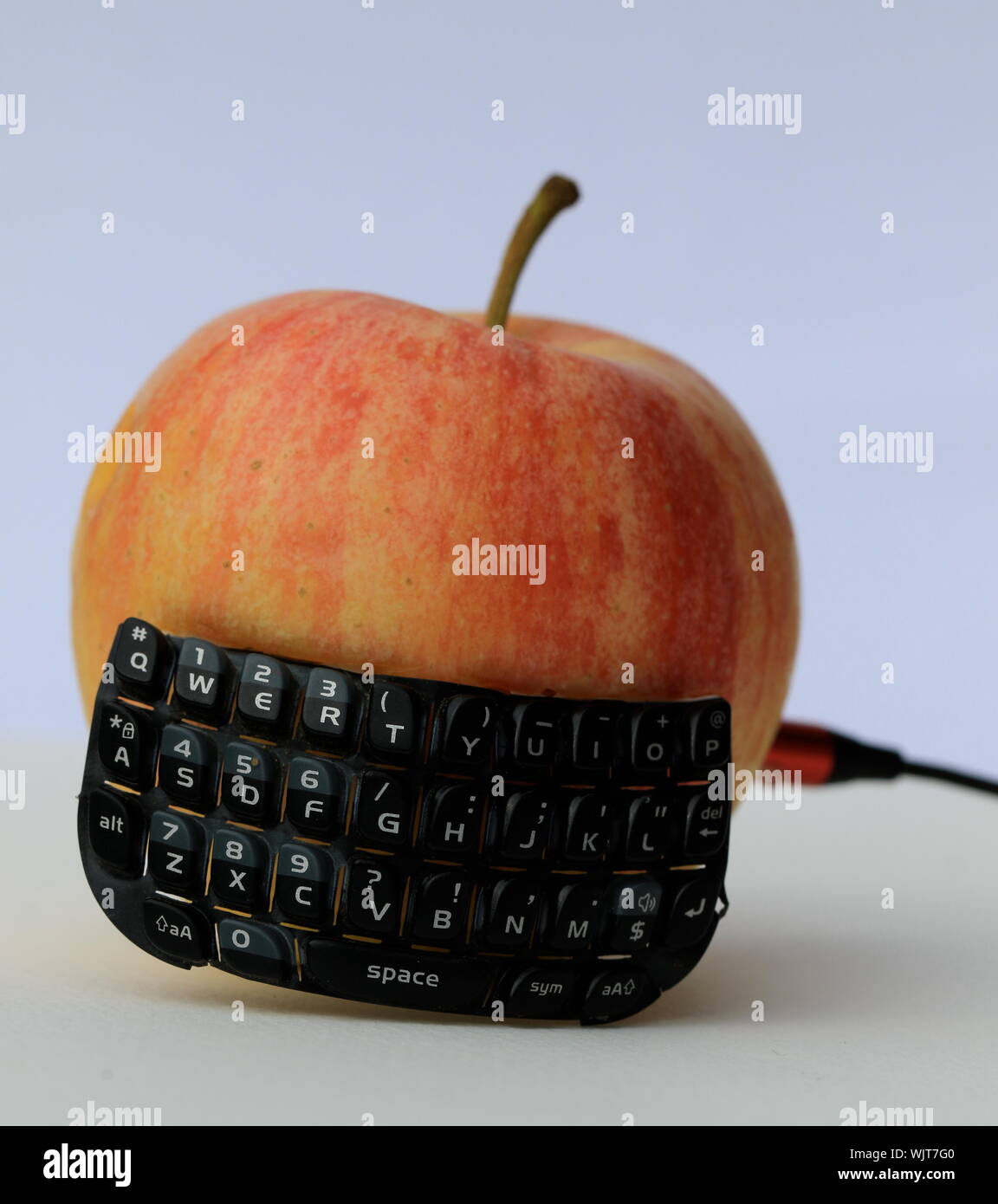 Close-up Of Apple With Keyboard Over White Background Stock Photo - Alamy