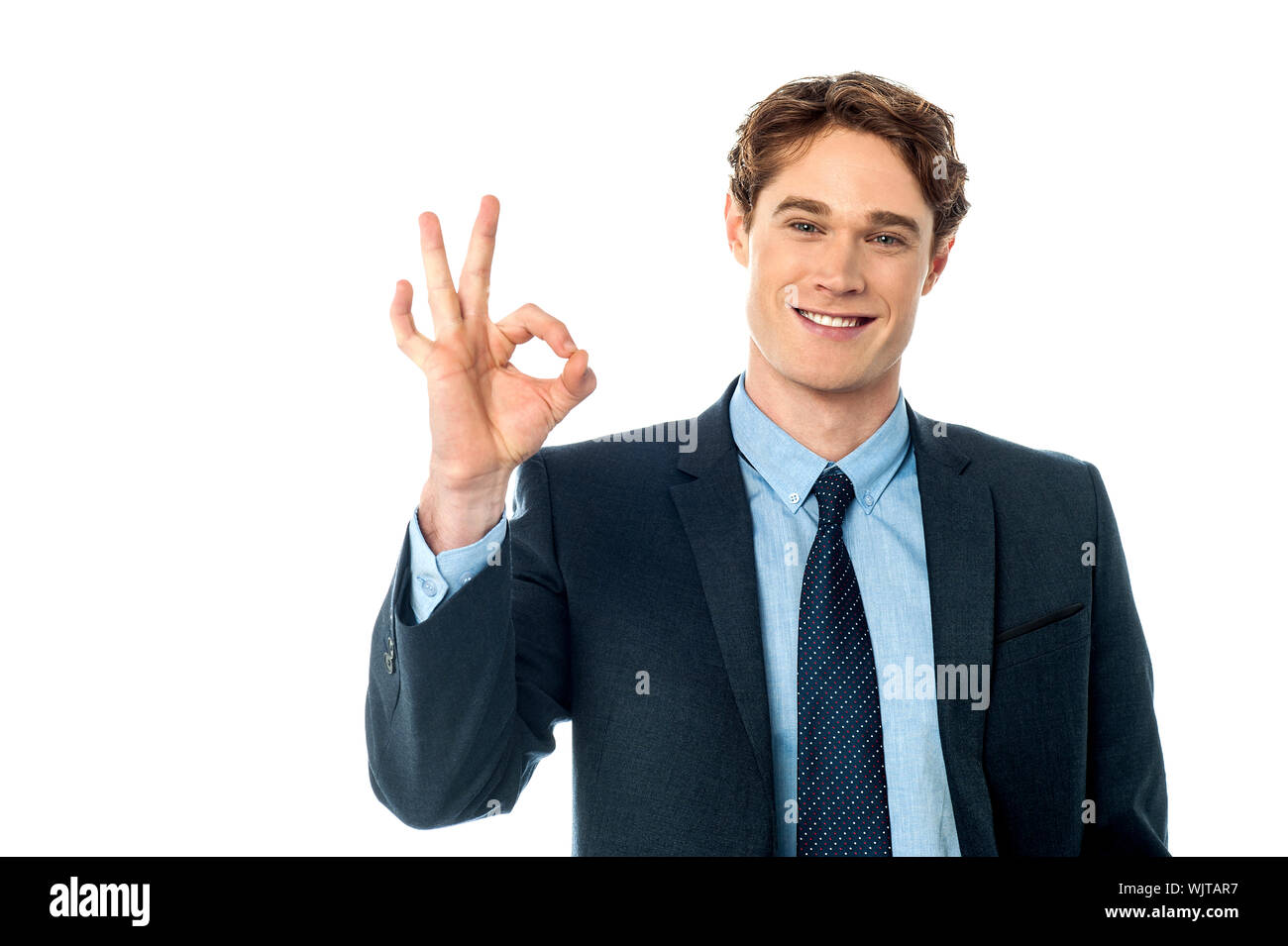 Handsome young businessman showing perfect gesture Stock Photo - Alamy