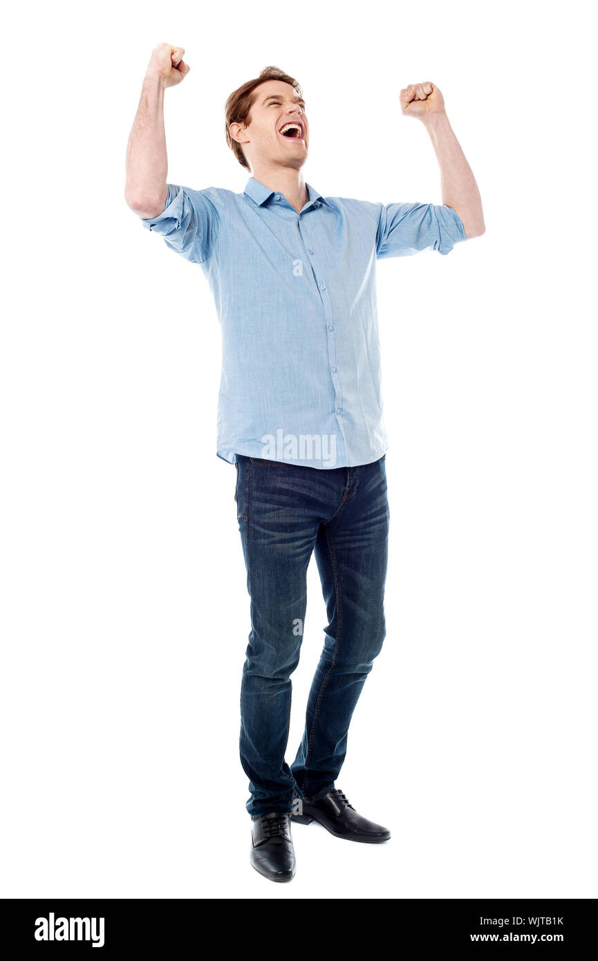 Handsome young man raising his arms in excitement Stock Photo - Alamy