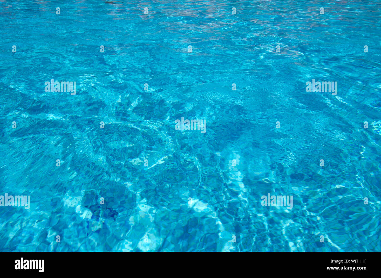 Blue pool water with sun reflections Stock Photo - Alamy