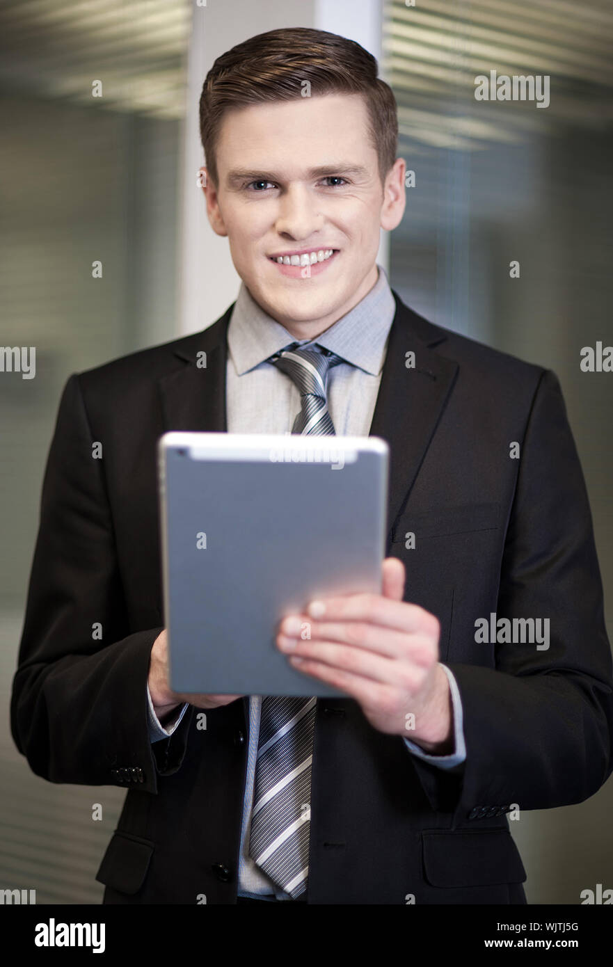 Corporate guy using tablet pc at workplace Stock Photo - Alamy