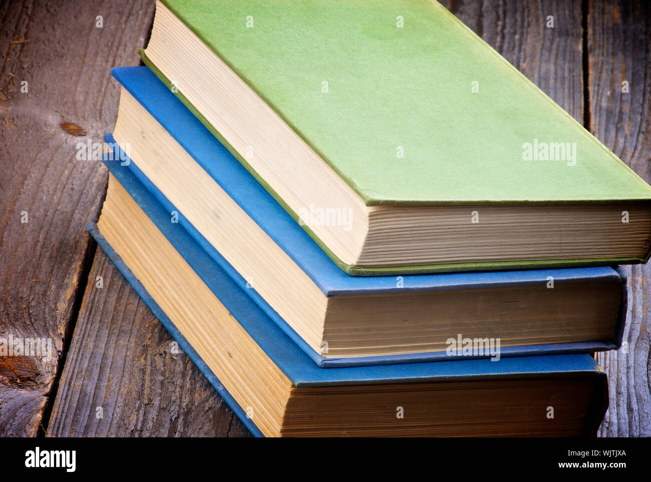 Pile of Three Old Books isolated on Rustic Wooden background Stock ...