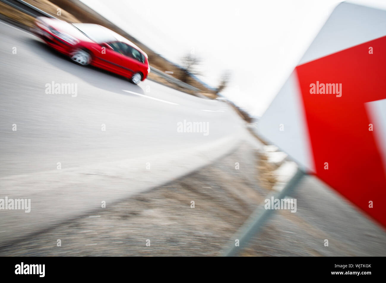 Traffic concept: car driving fast through a sharp turn (motion blur is ...
