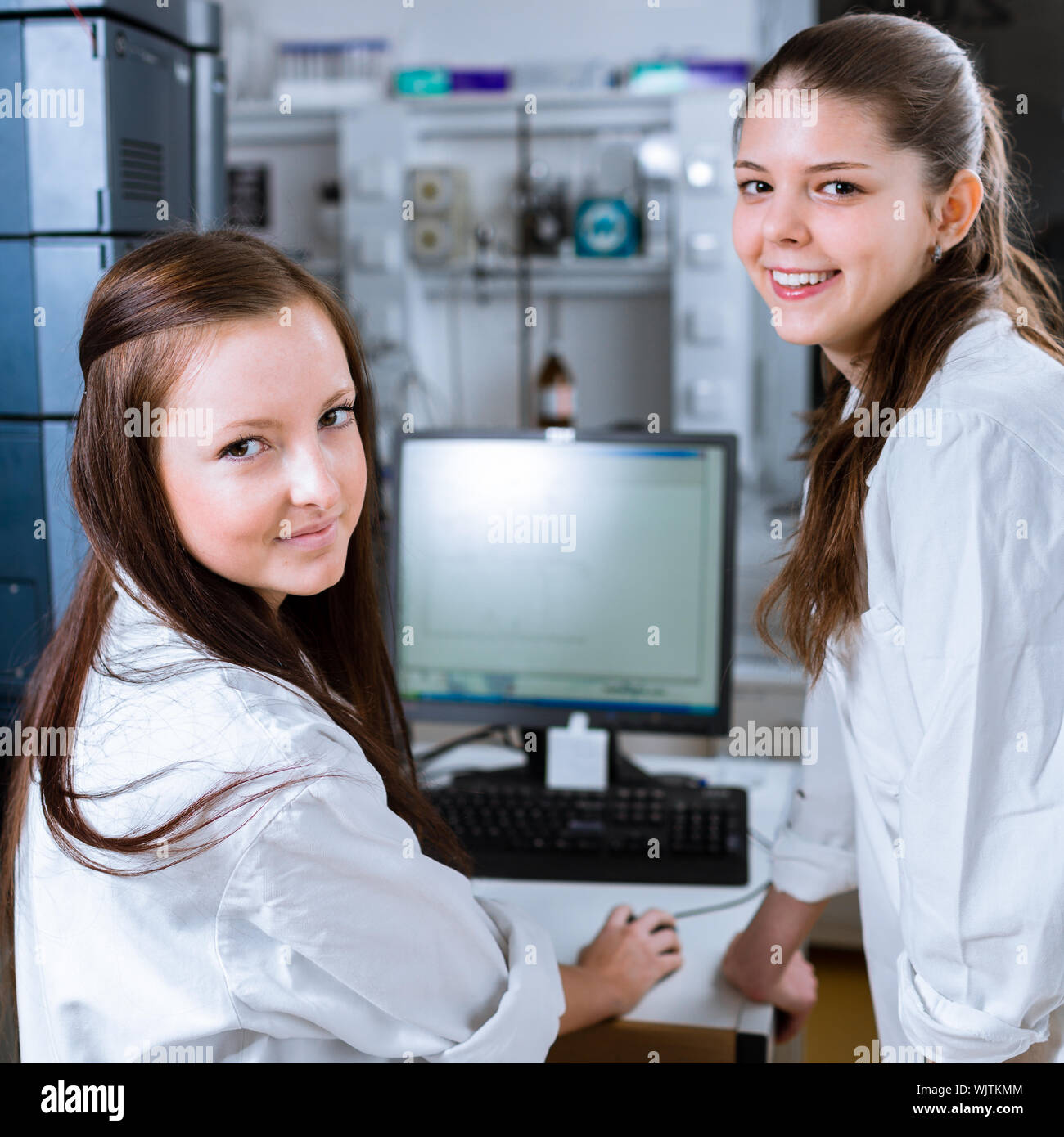 Two chemistry students carrying out experiments in a lab (shallow DOF ...