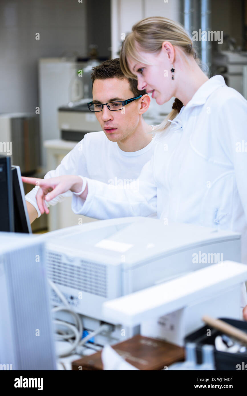 Two young researchers carrying out experiments in a lab (shallow DOF ...