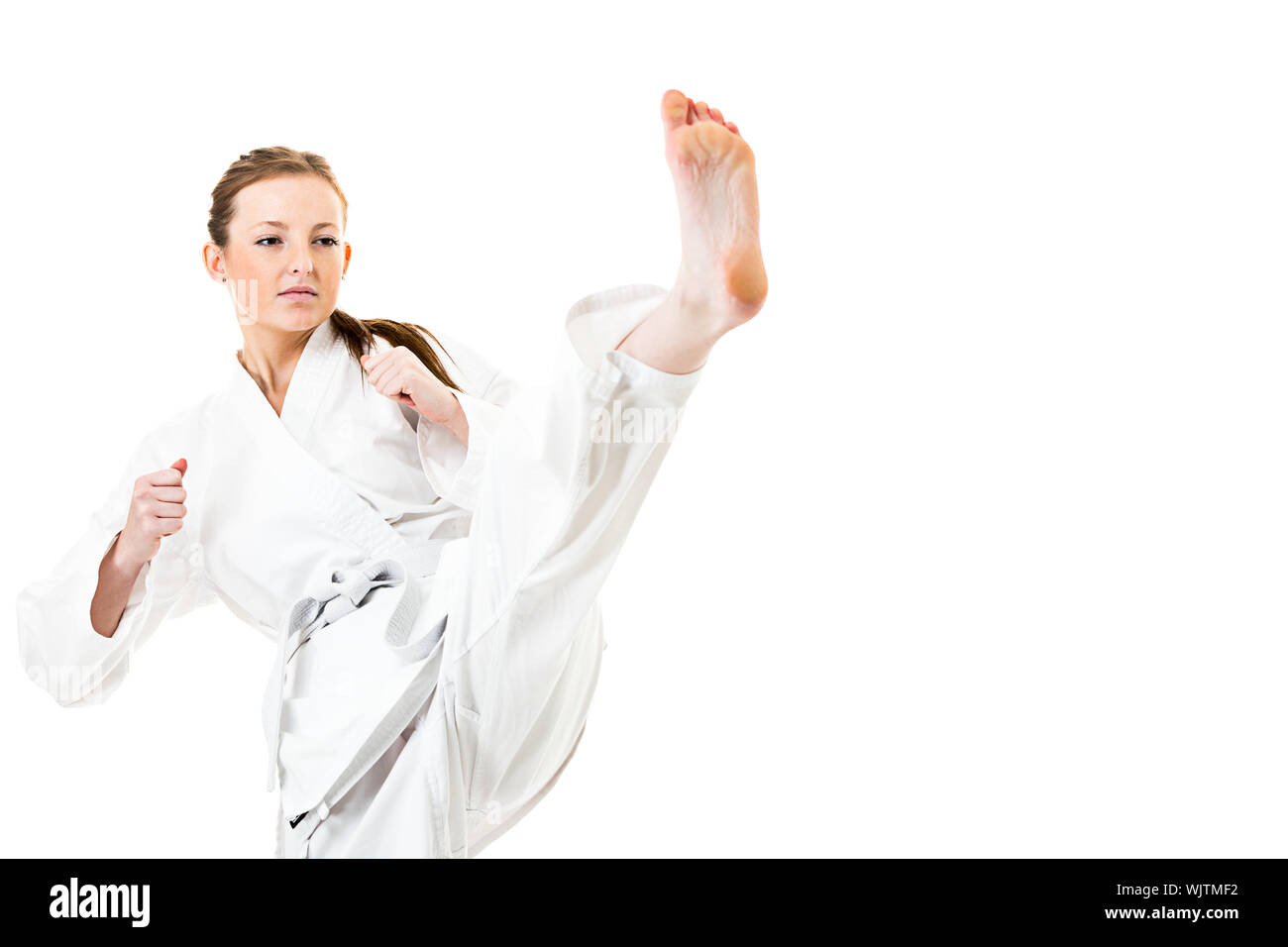 Beautiful caucasian, young, woman makes a kick in kimono on white ...