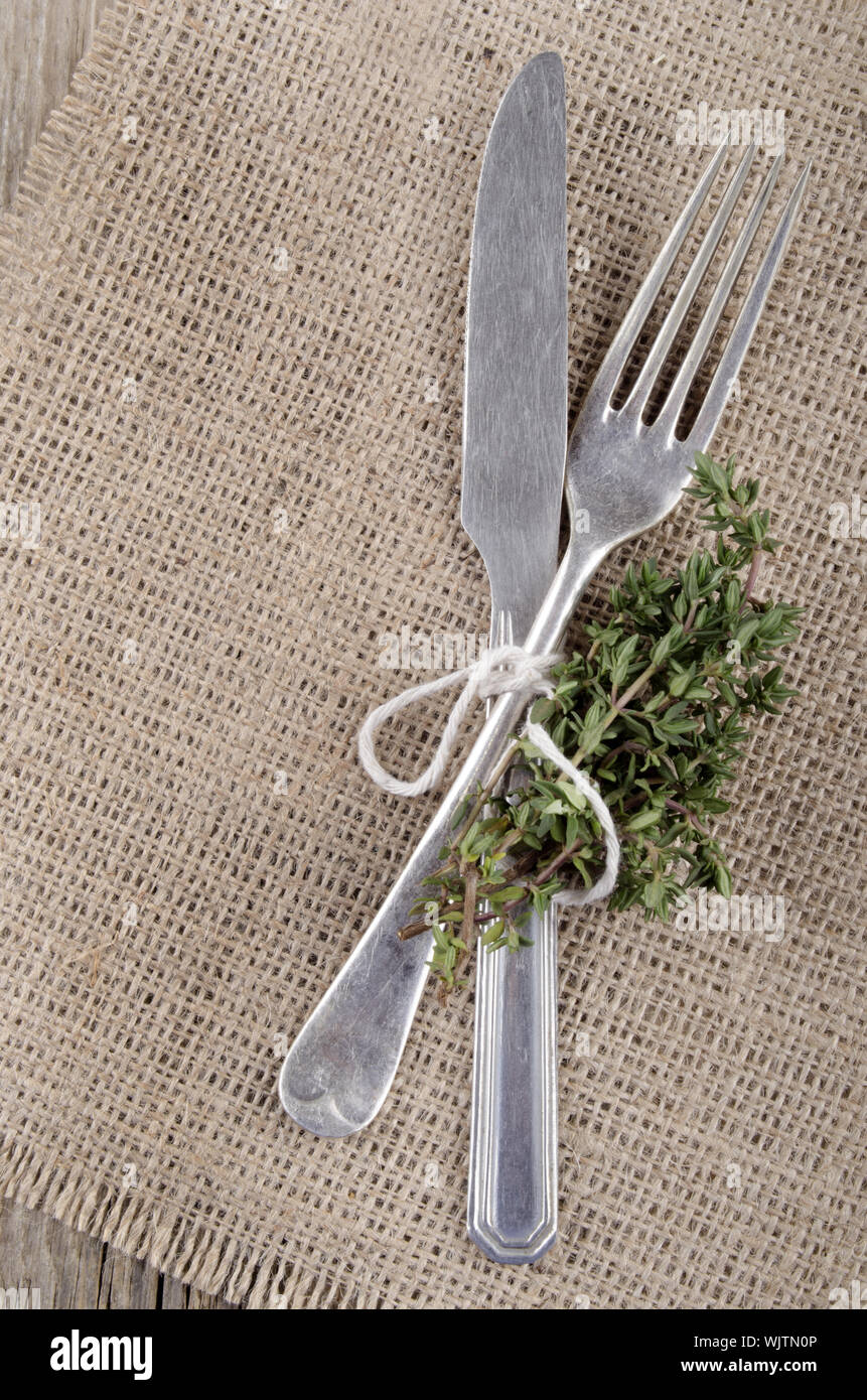 fork and knife with thyme on jute Stock Photo - Alamy