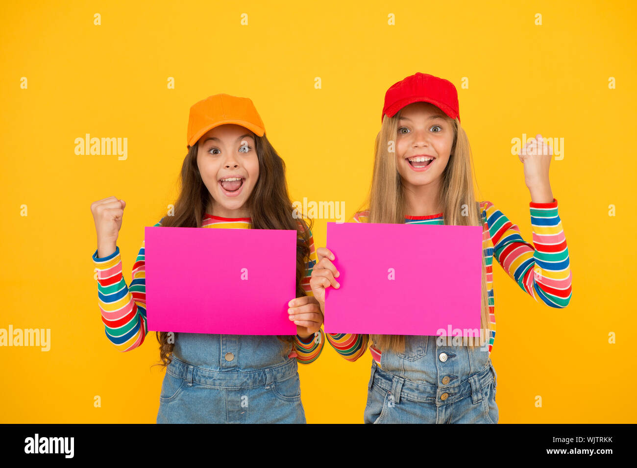 Your advertising wins. Happy small children showing pink paper sheets ...