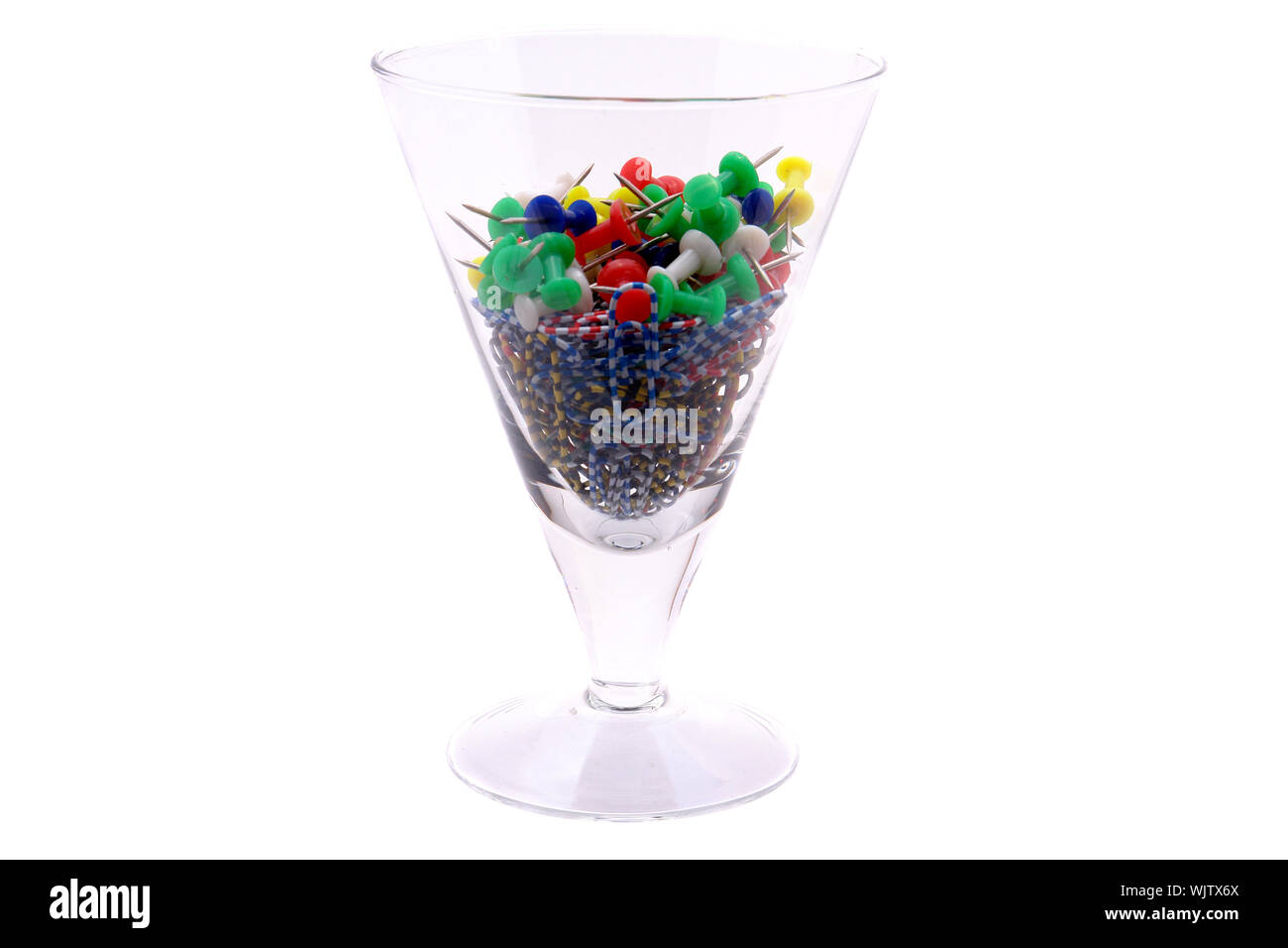 button and staples in tall wine glass Stock Photo - Alamy