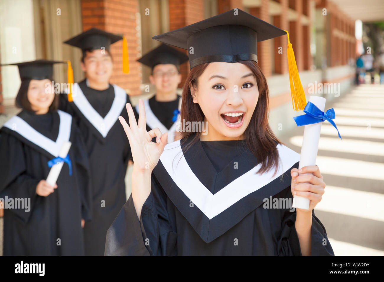 happy college graduate holding diploma and make a gesture Stock Photo ...