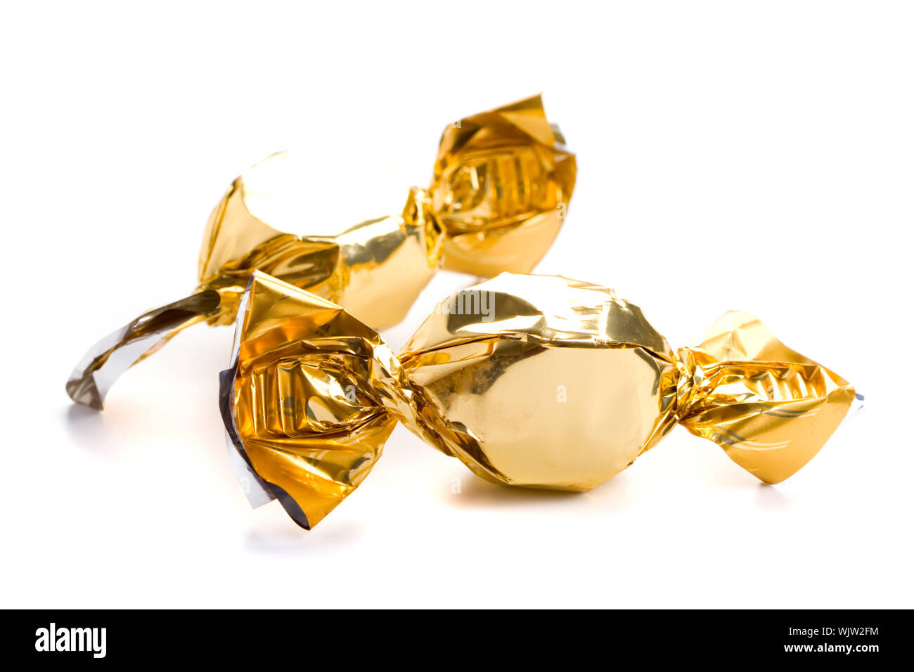 two golden sweets closeup on white background Stock Photo - Alamy