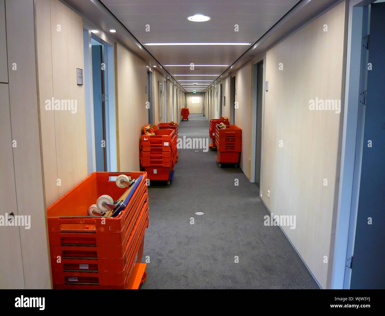 Office corridor with red removal crates Stock Photo - Alamy