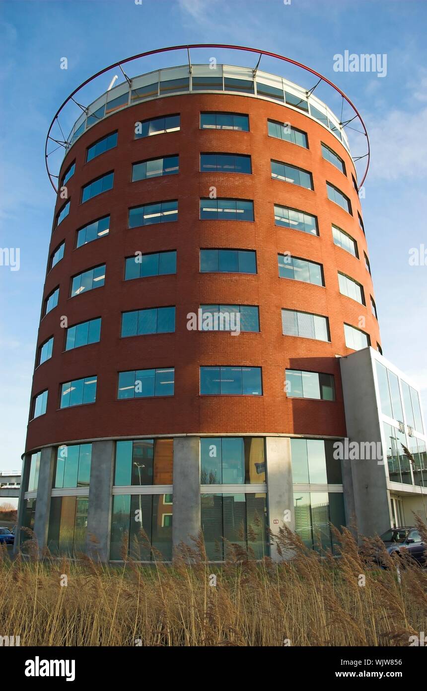 Modern round-shaped office building made of red brick and glass in ...