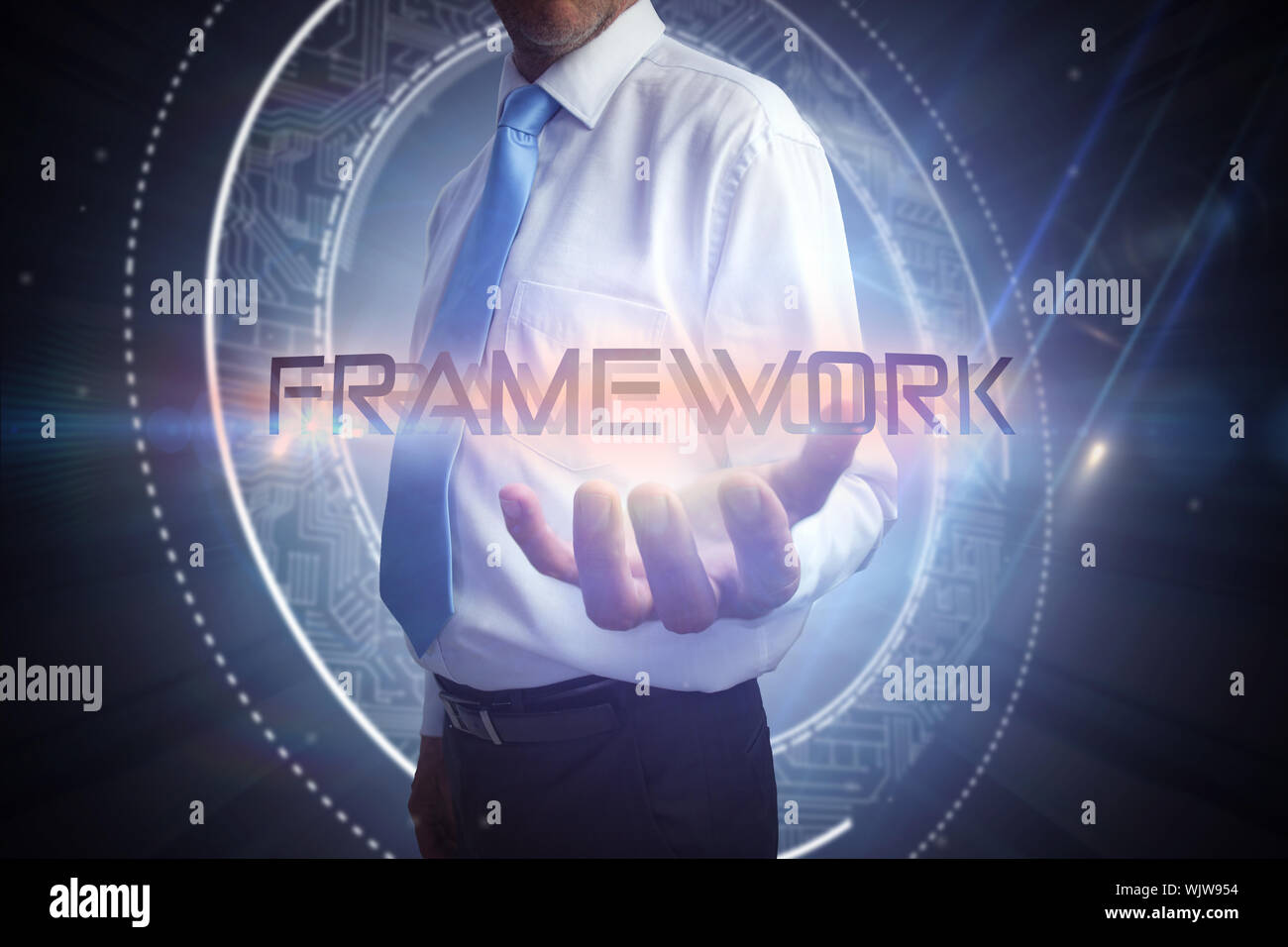Businessman presenting the word framework against black background with ...